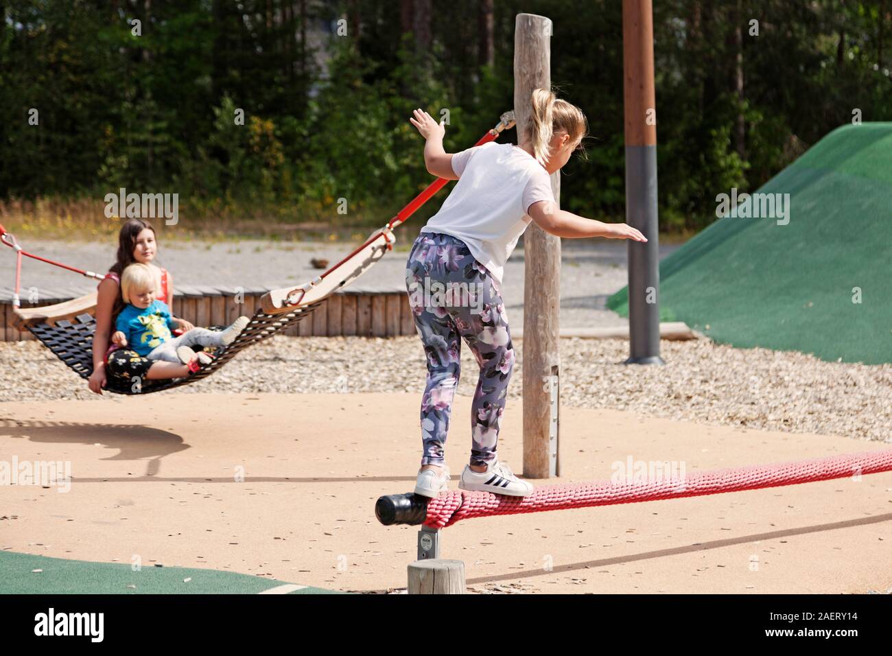 Umea, Norrland Sweden - July 29, 2019: a girl walks balancing on a bar ...