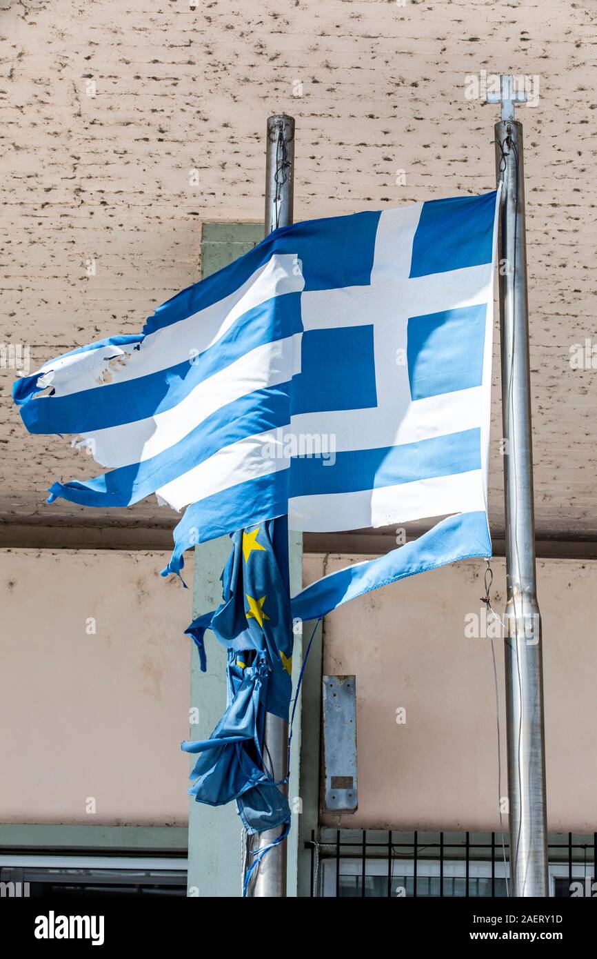 Greek national flag, shredded by the wind, behind it flag of the ...