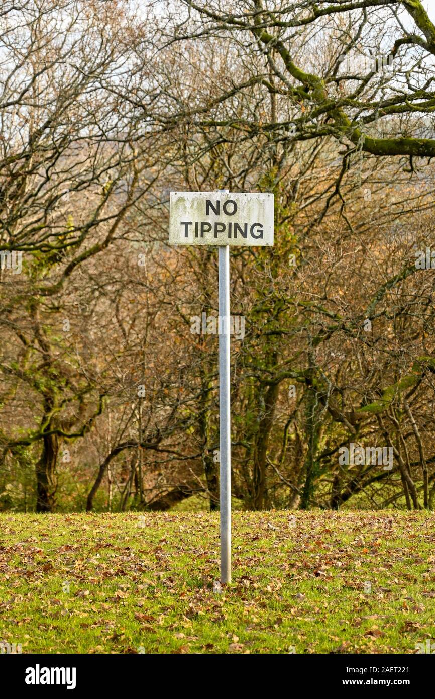 White "No tipping" sign covered in green algae isolated against a ...