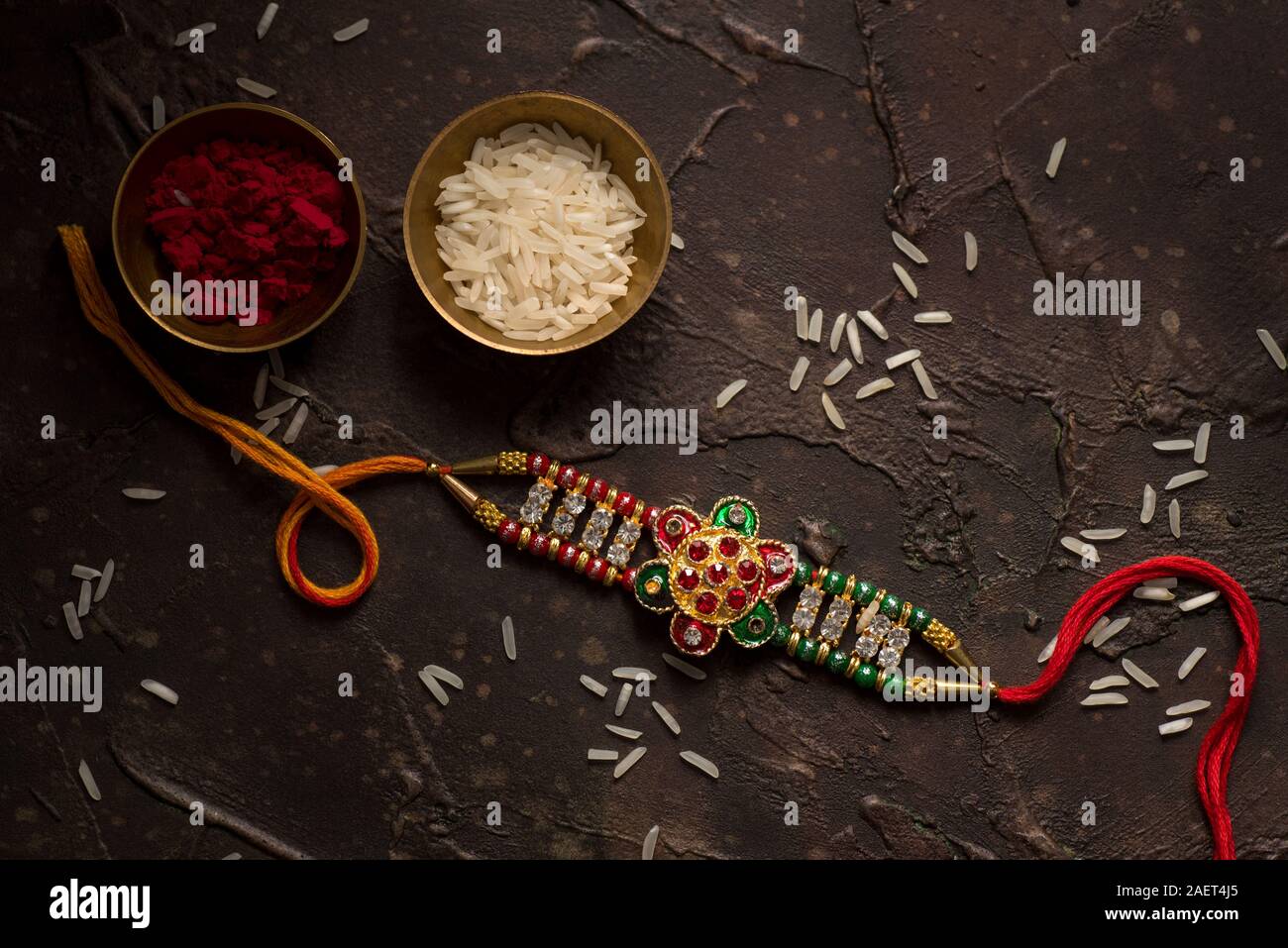 Raksha Bandhan background with an elegant Rakhi, Rice Grains and Kumkum ...