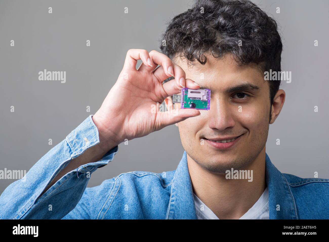 Young man holding a USB connectivity for standard SD memory cards with ...