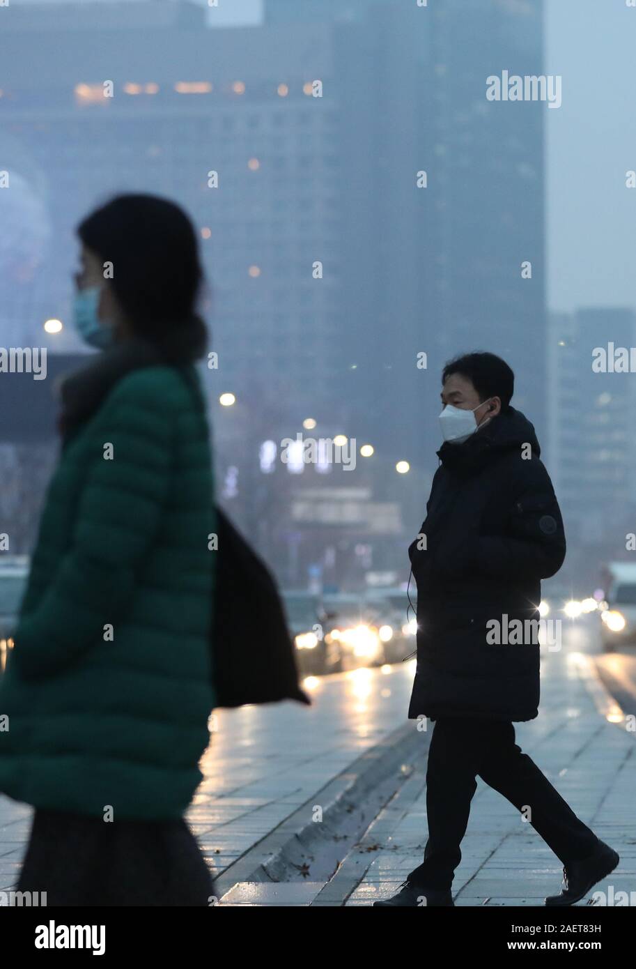 11th Dec, 2019. Air pollution Two people wear masks as they walk on a ...