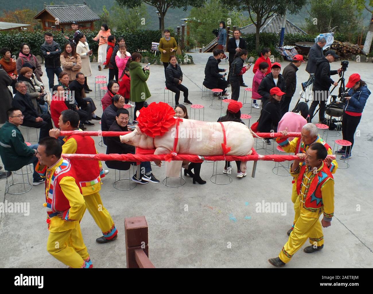 People carry a pig with a sedan chair for the pig sacrifice section at ...