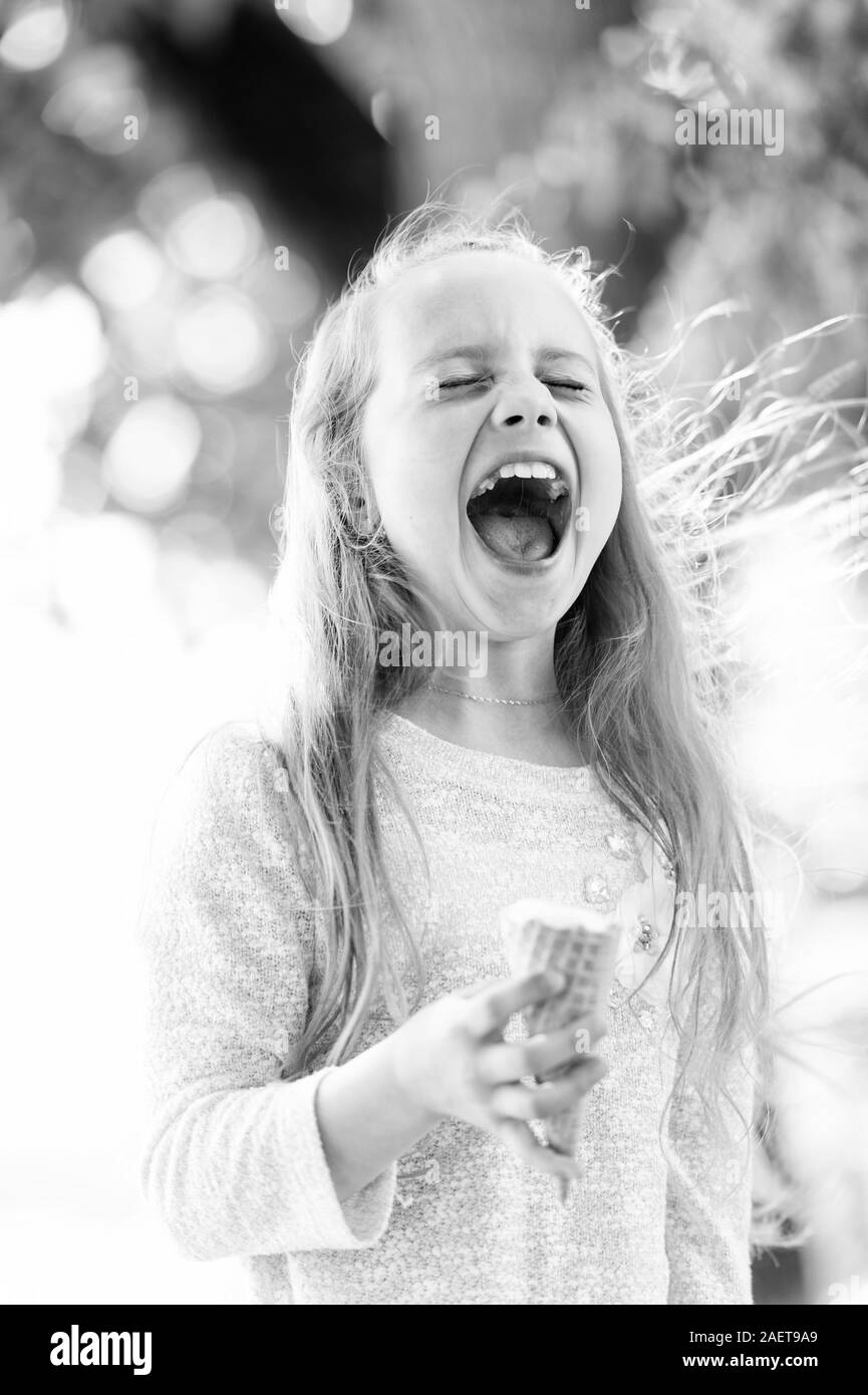 Ice cream makes her fall into euphoria. Cute little girl eating ice ...