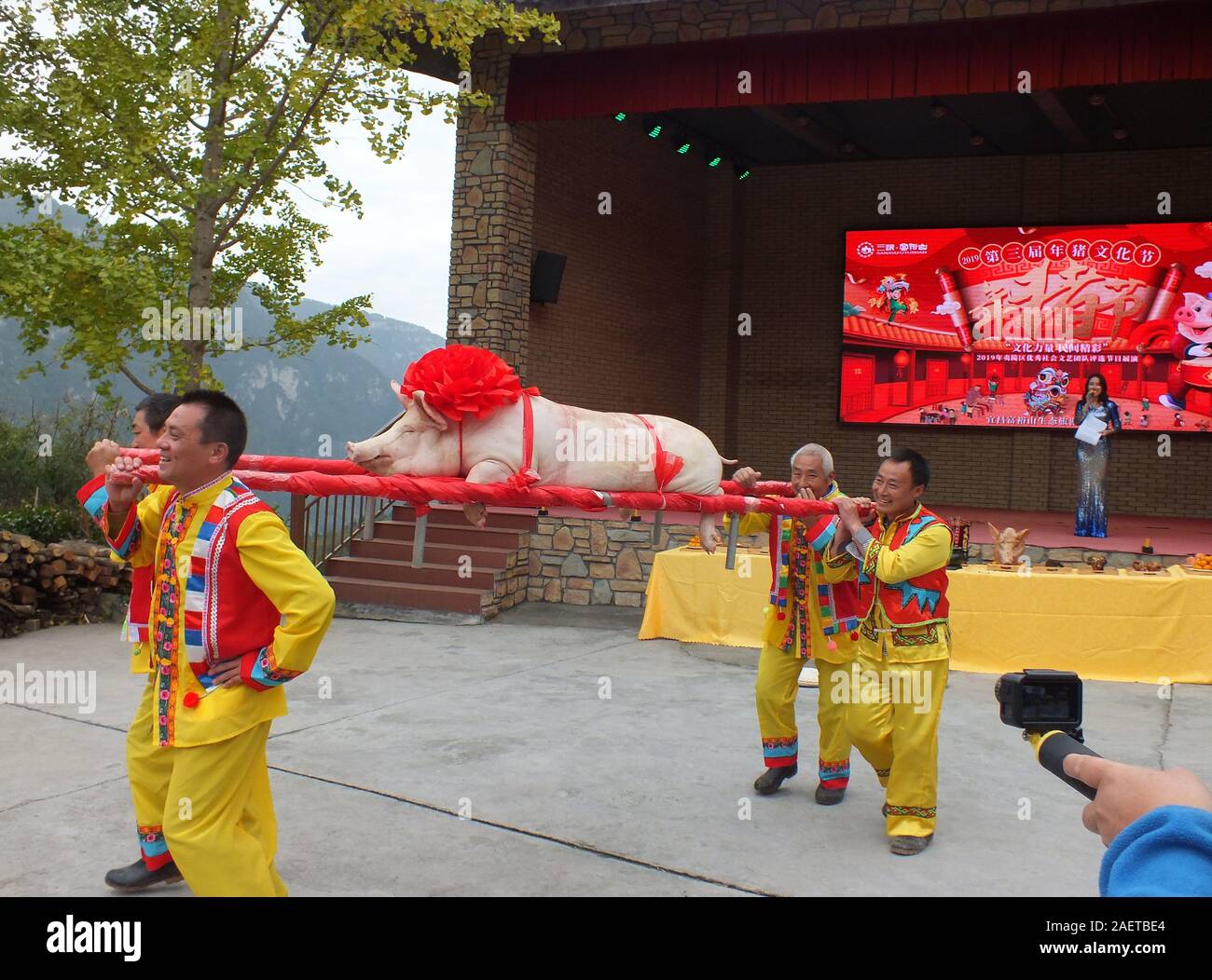 People carry a pig with a sedan chair for the pig sacrifice section at ...