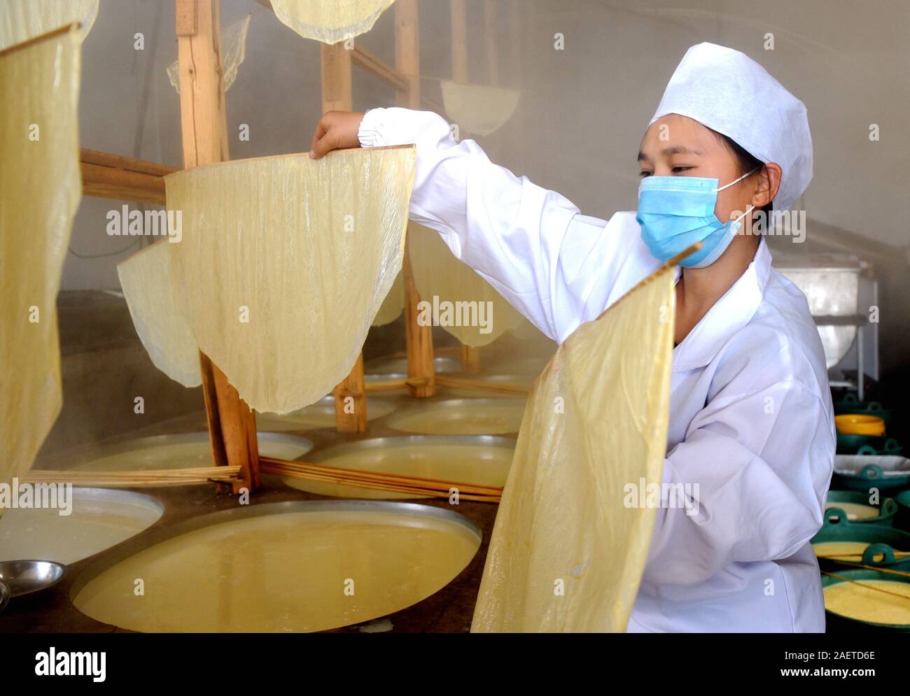 A person puts tofu skin on a drying shack in Xianju county, Taizhou ...