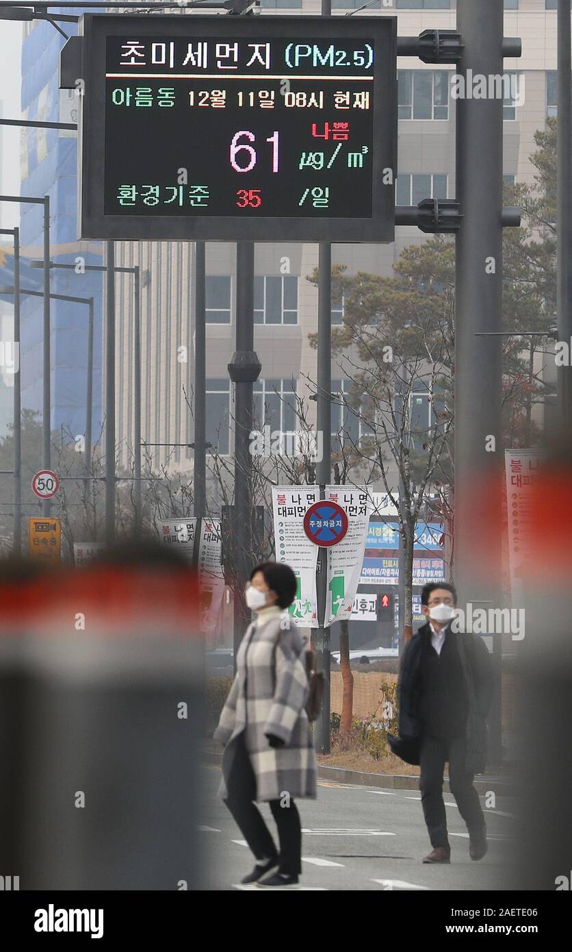 11th Dec, 2019. Air pollution Two people wearing masks walk on a street ...