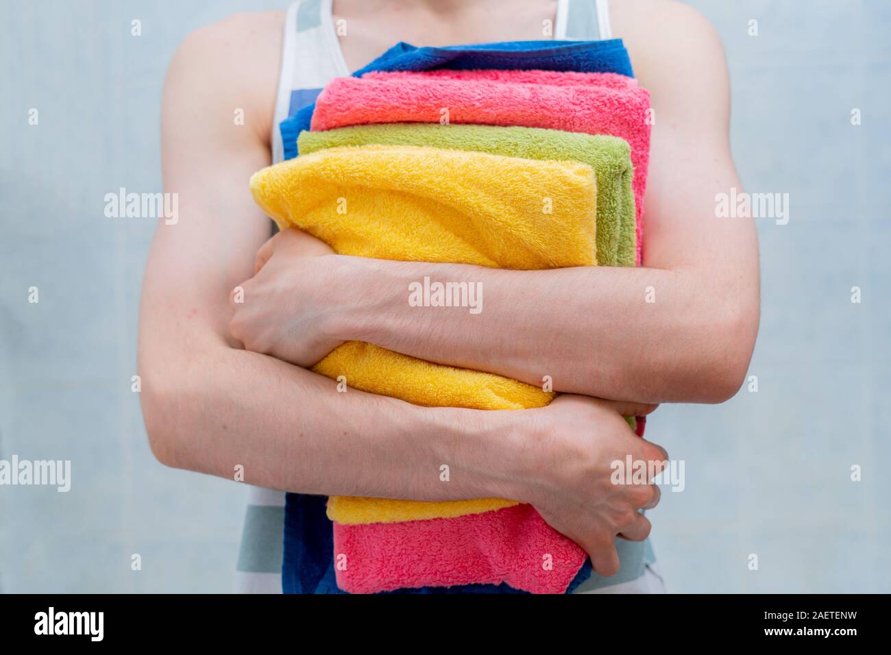 person in the laundry holding the stack of color clean towels Stock ...