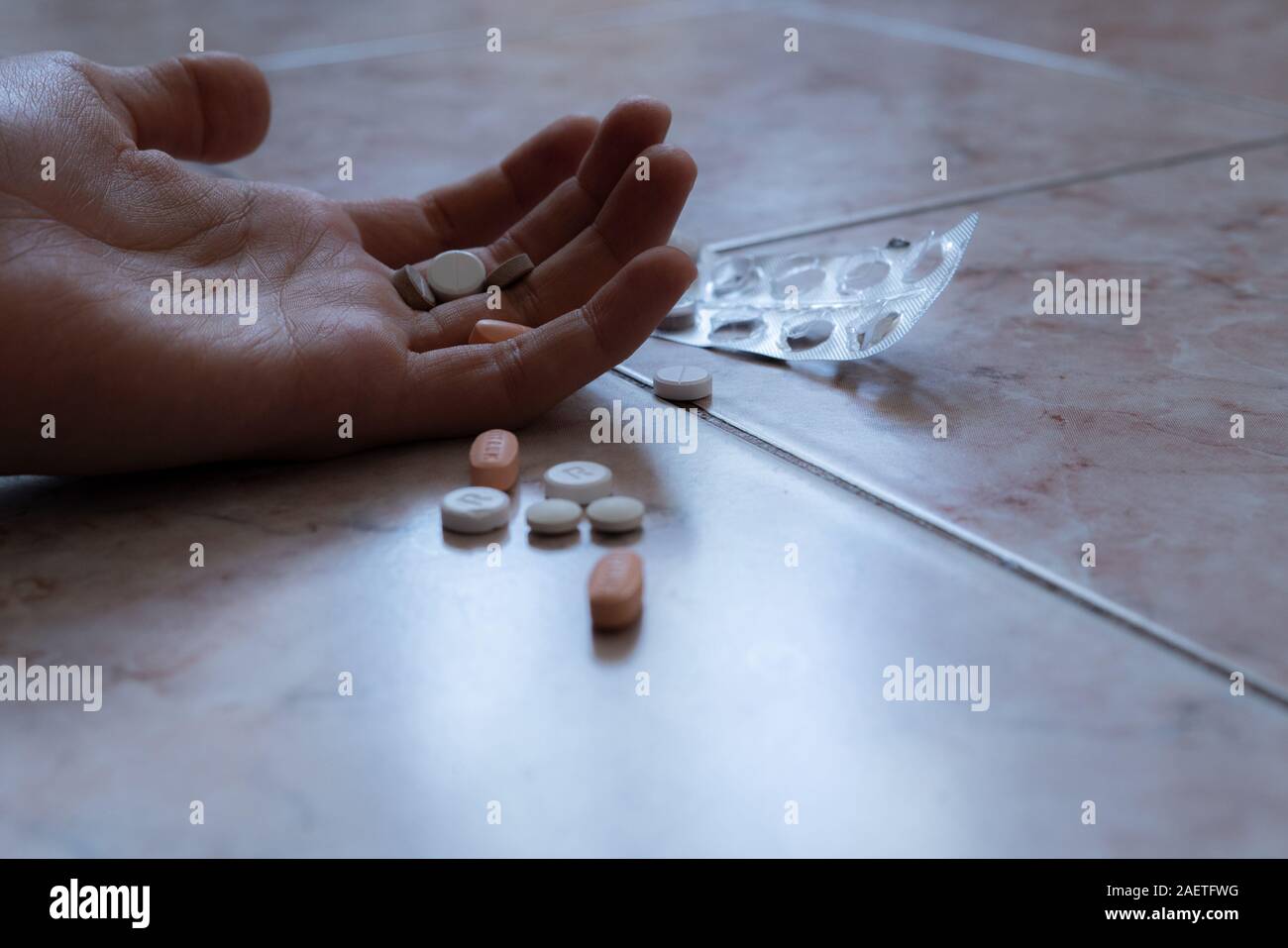 a person lying on the floor, hand with pills, medicine overdose Stock ...