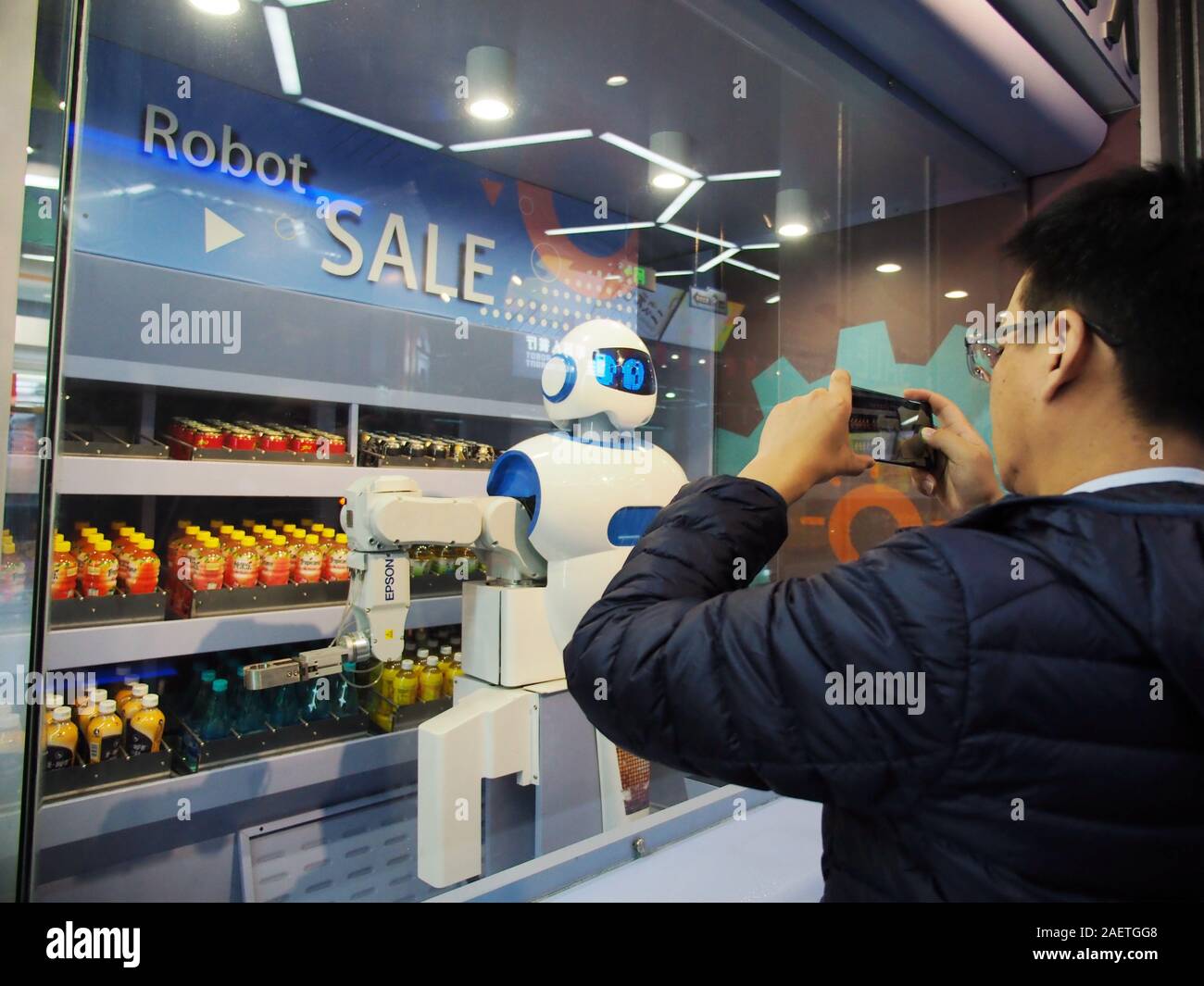 A person takes photos of a Robot Sale vendor stall at the China Soong ...