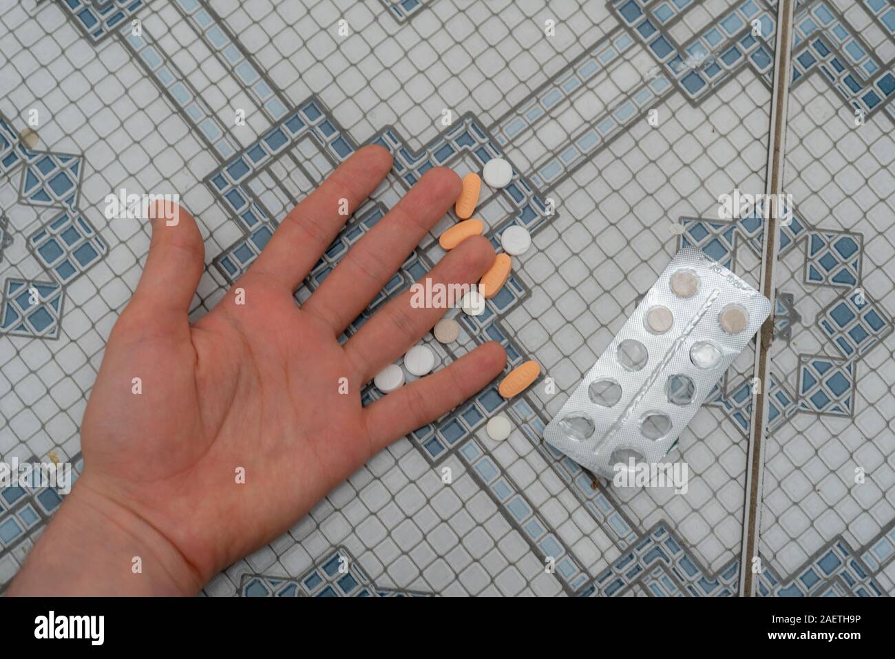 a person lying on the floor, hand with pills, medicine overdose Stock ...