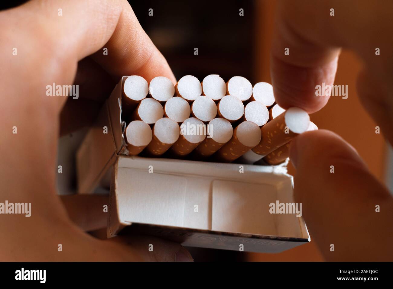 close up of person's hand pick a cigarette from the carton pack box ...