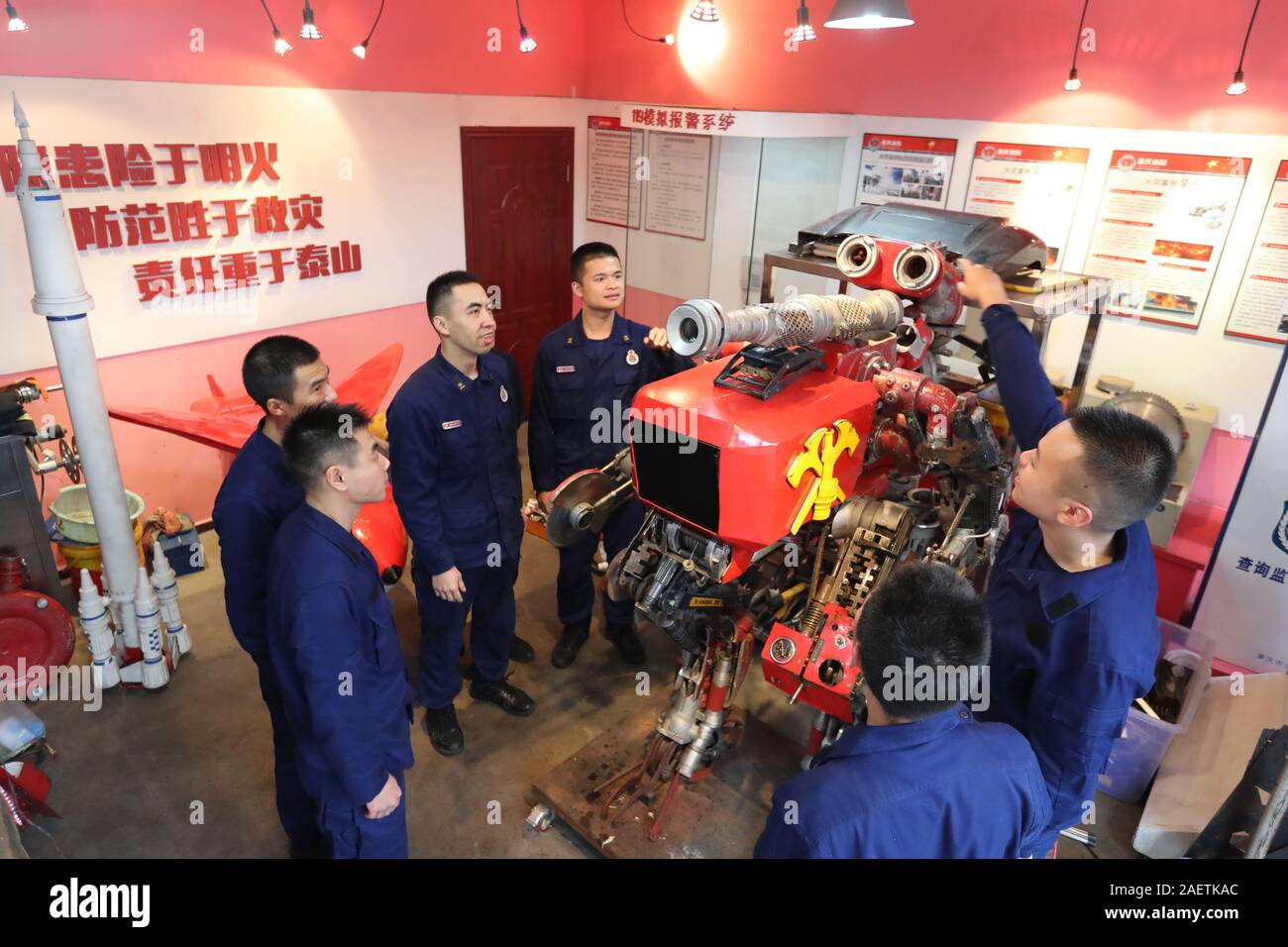 Firefighters observe a firefighting robot built by Liu Jie out of scrap ...