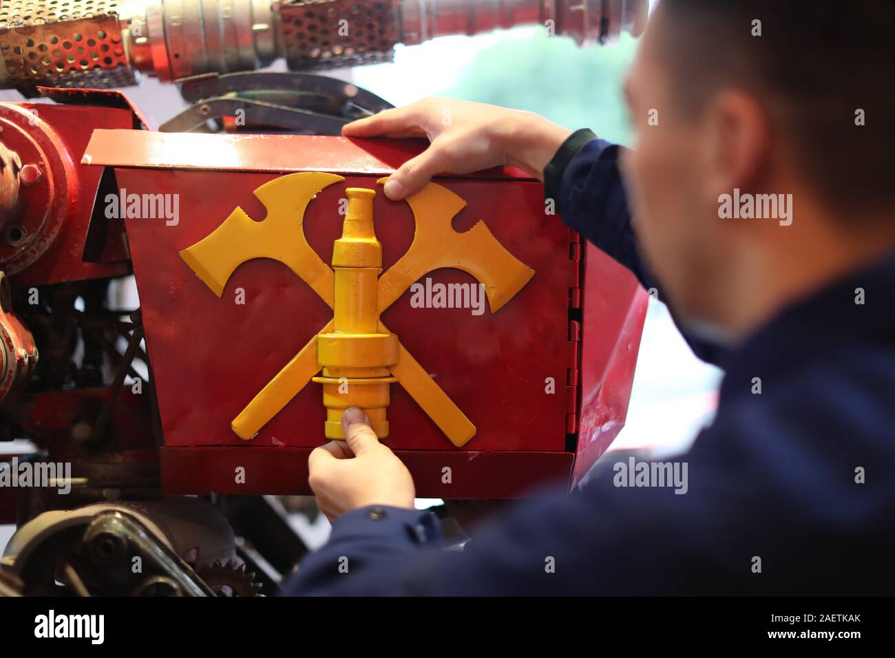 Liu Jie puts a firefighter logo on a firefighting robot built out of ...