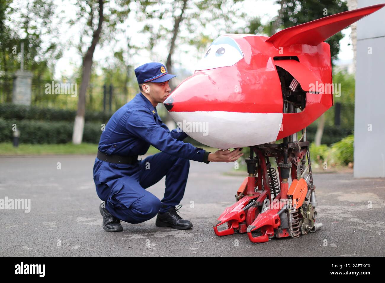 Liu Jie checks on a firefighting plane robot built out of scrap ...