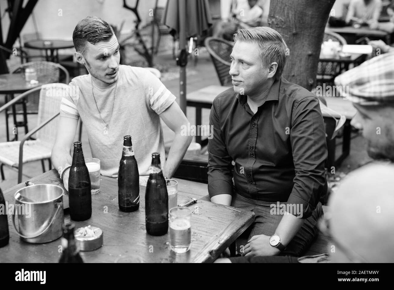 Group of men hanging out and relaxing together in the backyard Stock ...