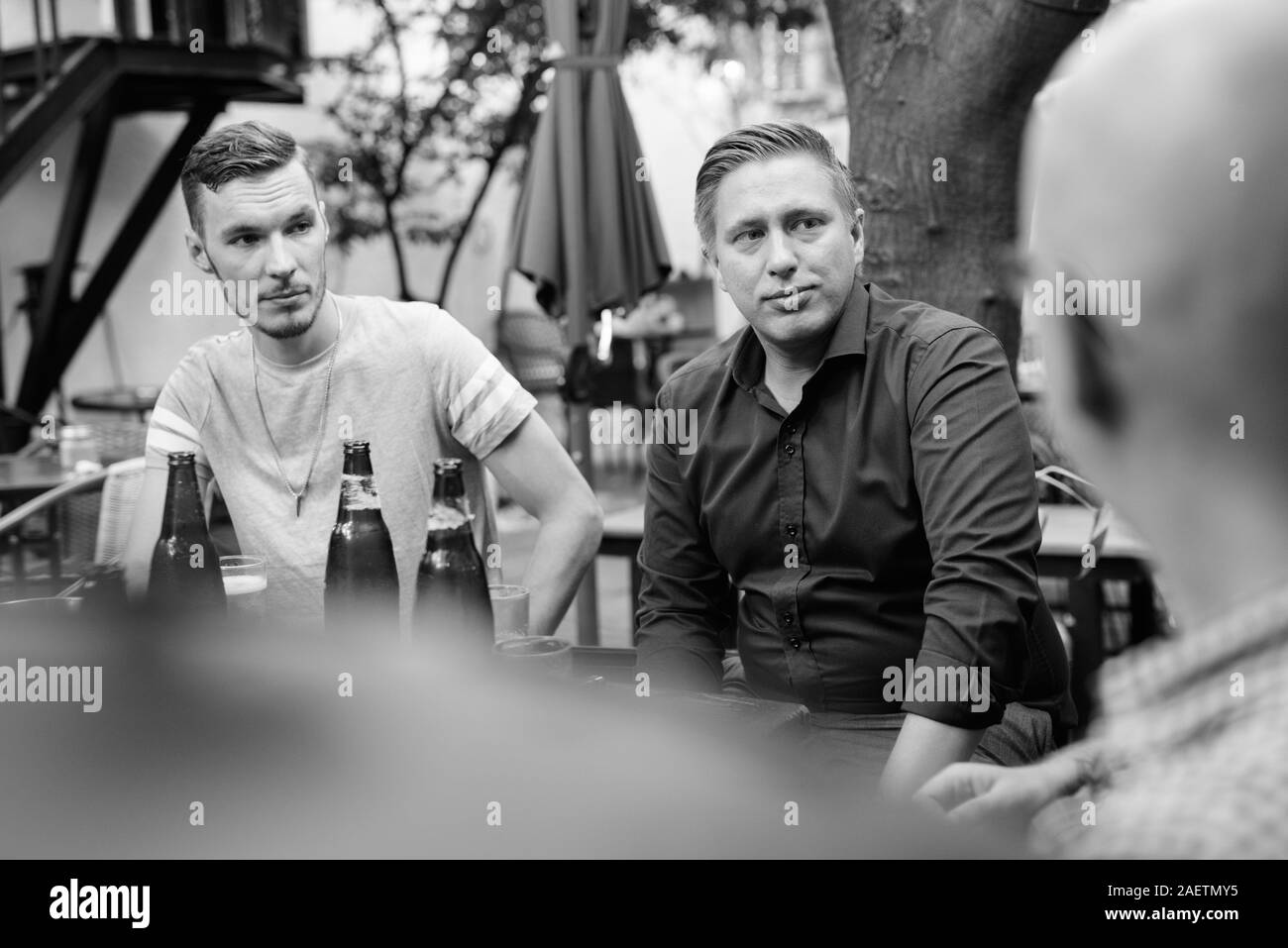 Group of men hanging out and relaxing together in the backyard Stock ...