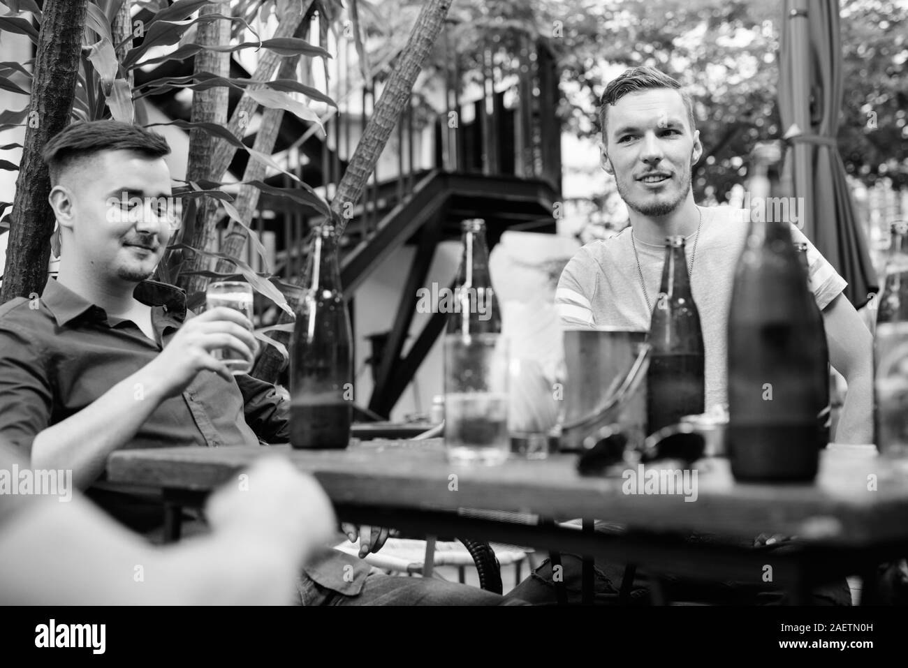Group of men hanging out and relaxing together in the backyard Stock ...
