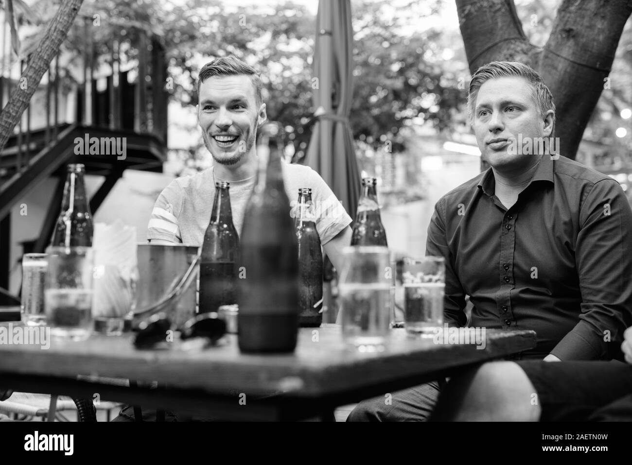 Group of men hanging out and relaxing together in the backyard Stock ...