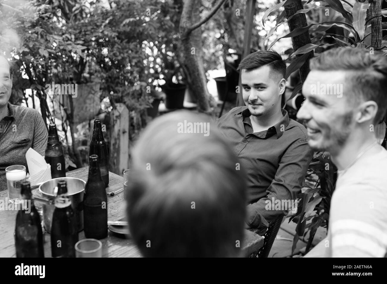 Group of men hanging out and relaxing together in the backyard Stock ...