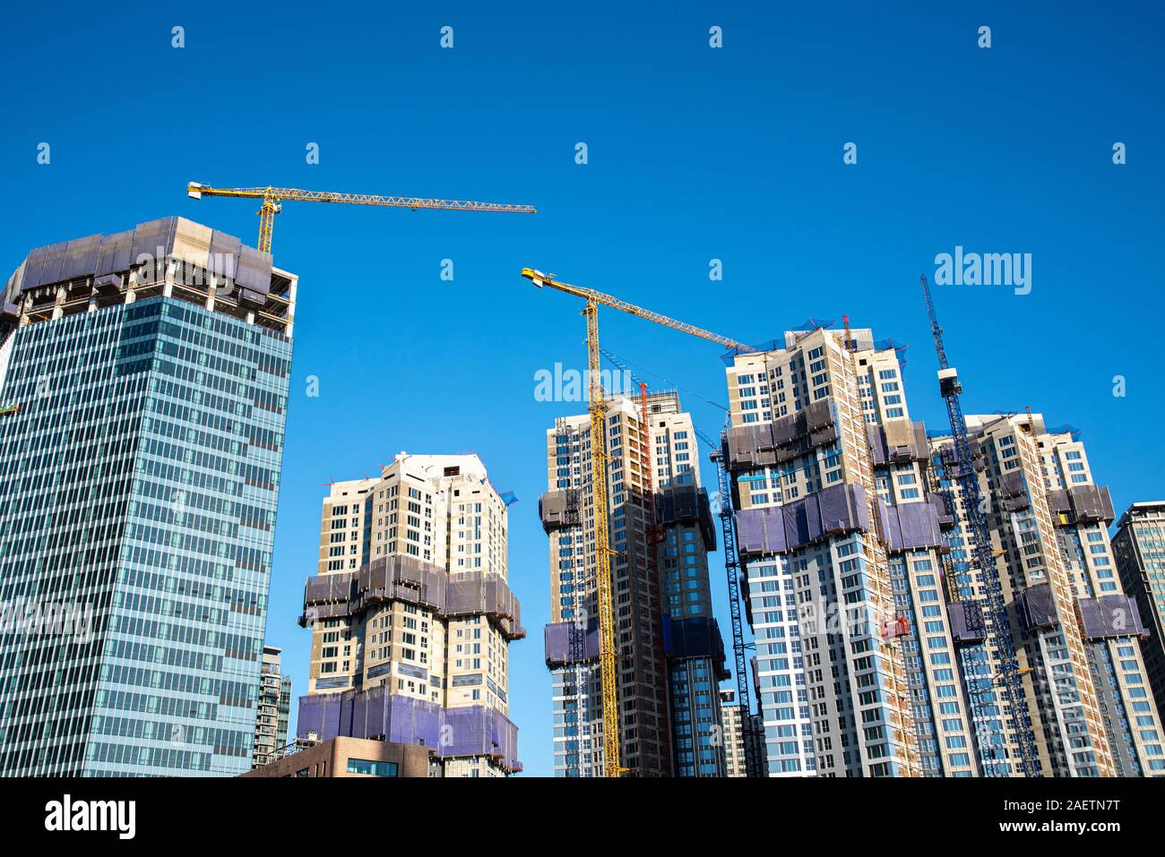Modern skyscrapers under construction with tower cranes. Industry ...