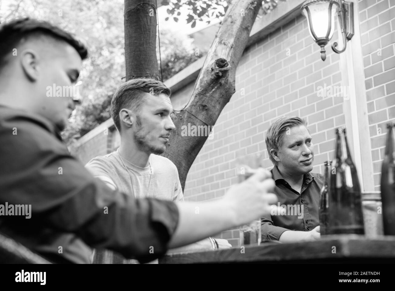 Group of men hanging out and relaxing together in the backyard Stock ...