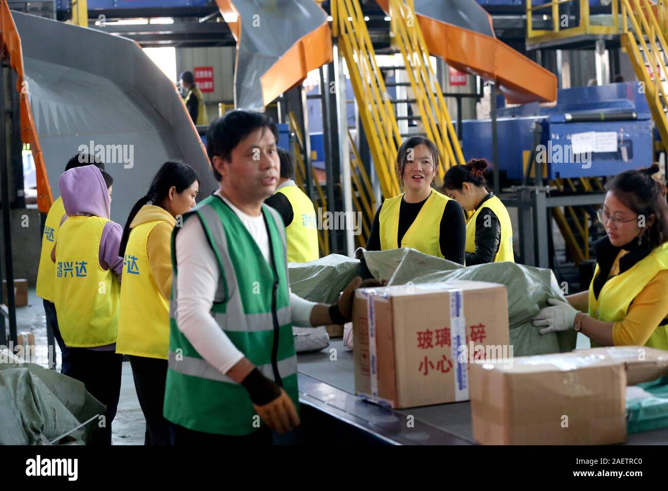 Workers at the EMS (Express Mail Service) logistics center sort out ...