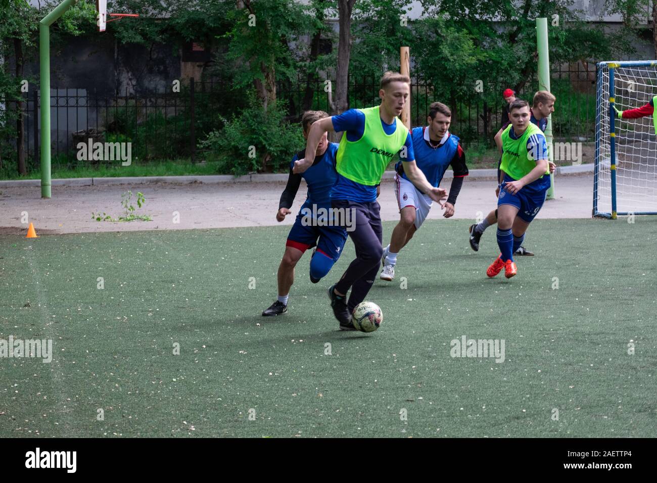 Street domestic playing soccer. Young guys play soccer on a green grass ...