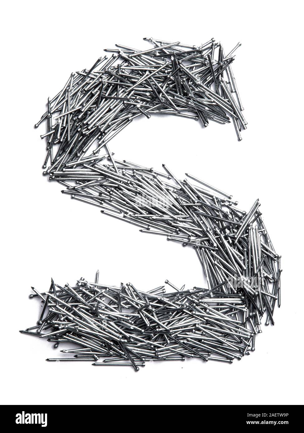 Letter S of the English alphabet from small iron nails on a white ...