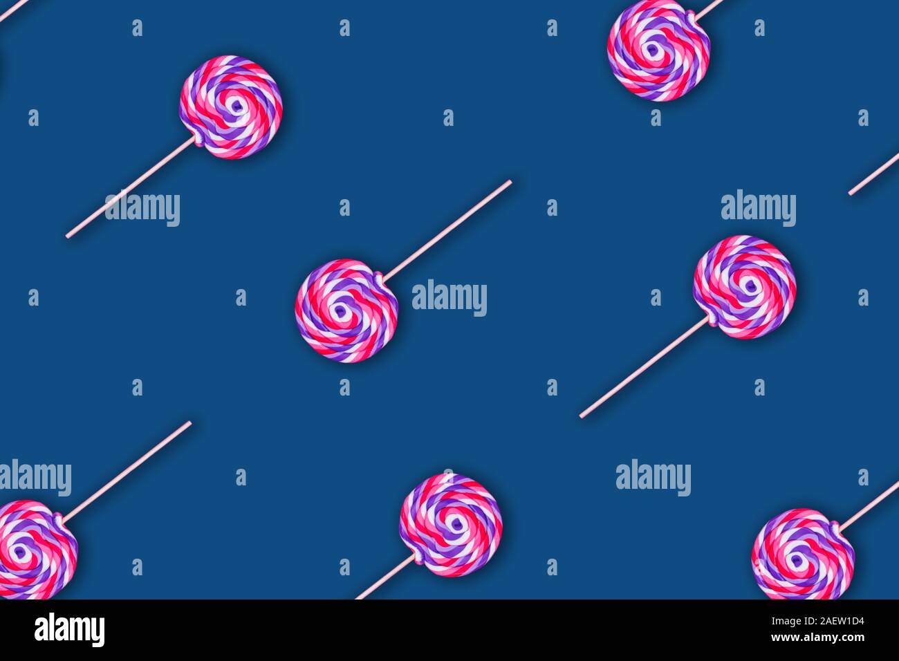 Pattern of giant pink lollipops on solid classic blue background ...