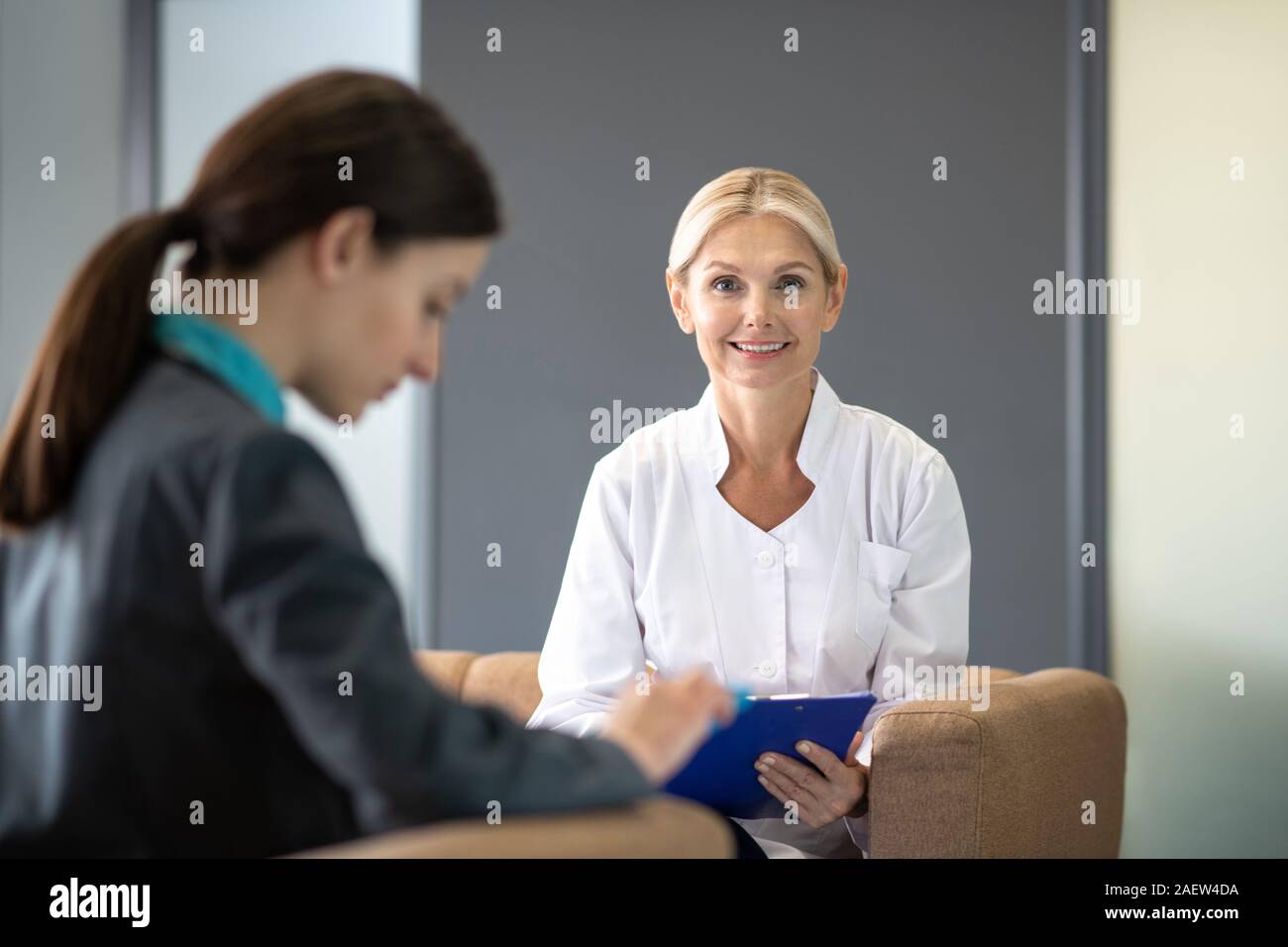 Dark-haired young cute female intern making notes Stock Photo - Alamy