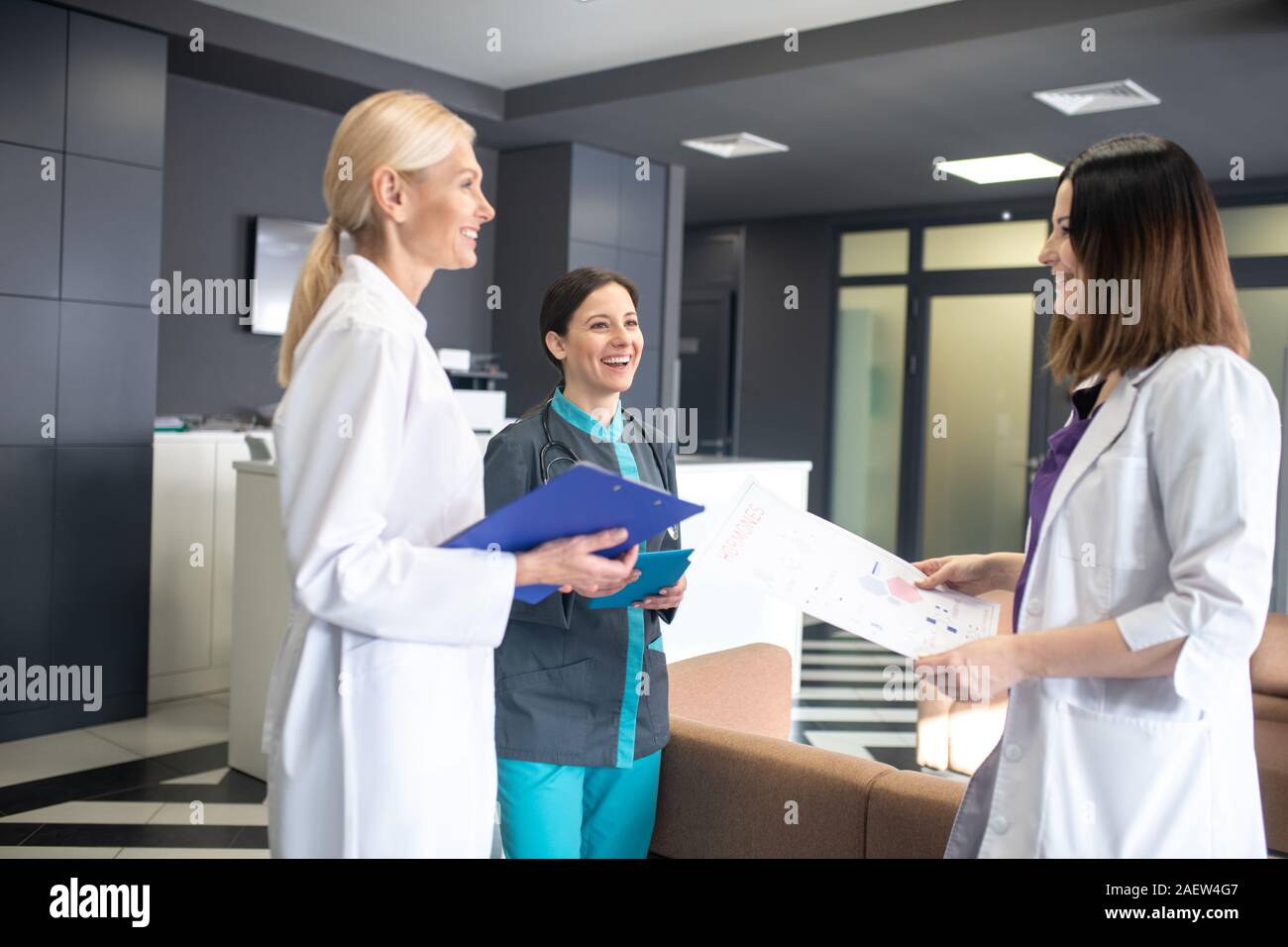 Three female doctors talking in the corridor Stock Photo - Alamy