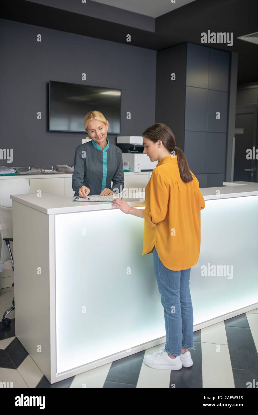 Blond receptionist in clinic offering time to a patient Stock Photo - Alamy