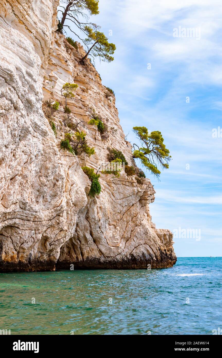 Beautiful pebble beach surrounded by high massive white limestone rocky ...