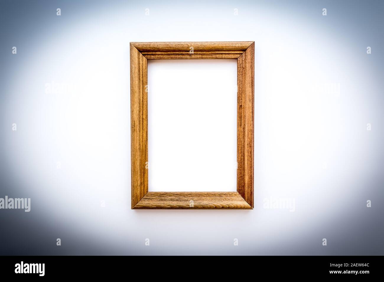A simple wooden vertical photo frame close-up with an isolated white ...