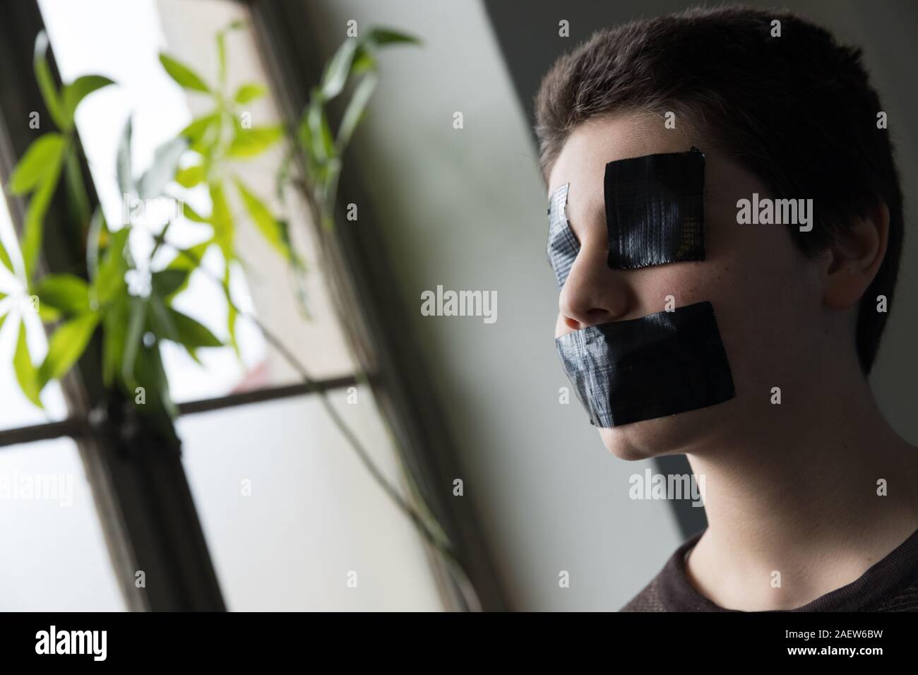 Boy with tape on the mouth and eyes. Communication message Stock Photo ...