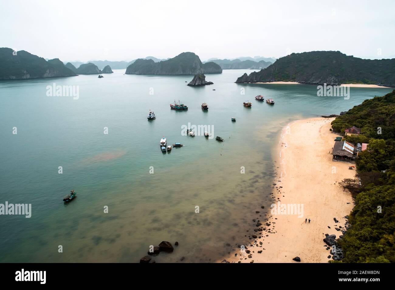 a view of a sandy beach and Halong bay with some boats shot from the ...