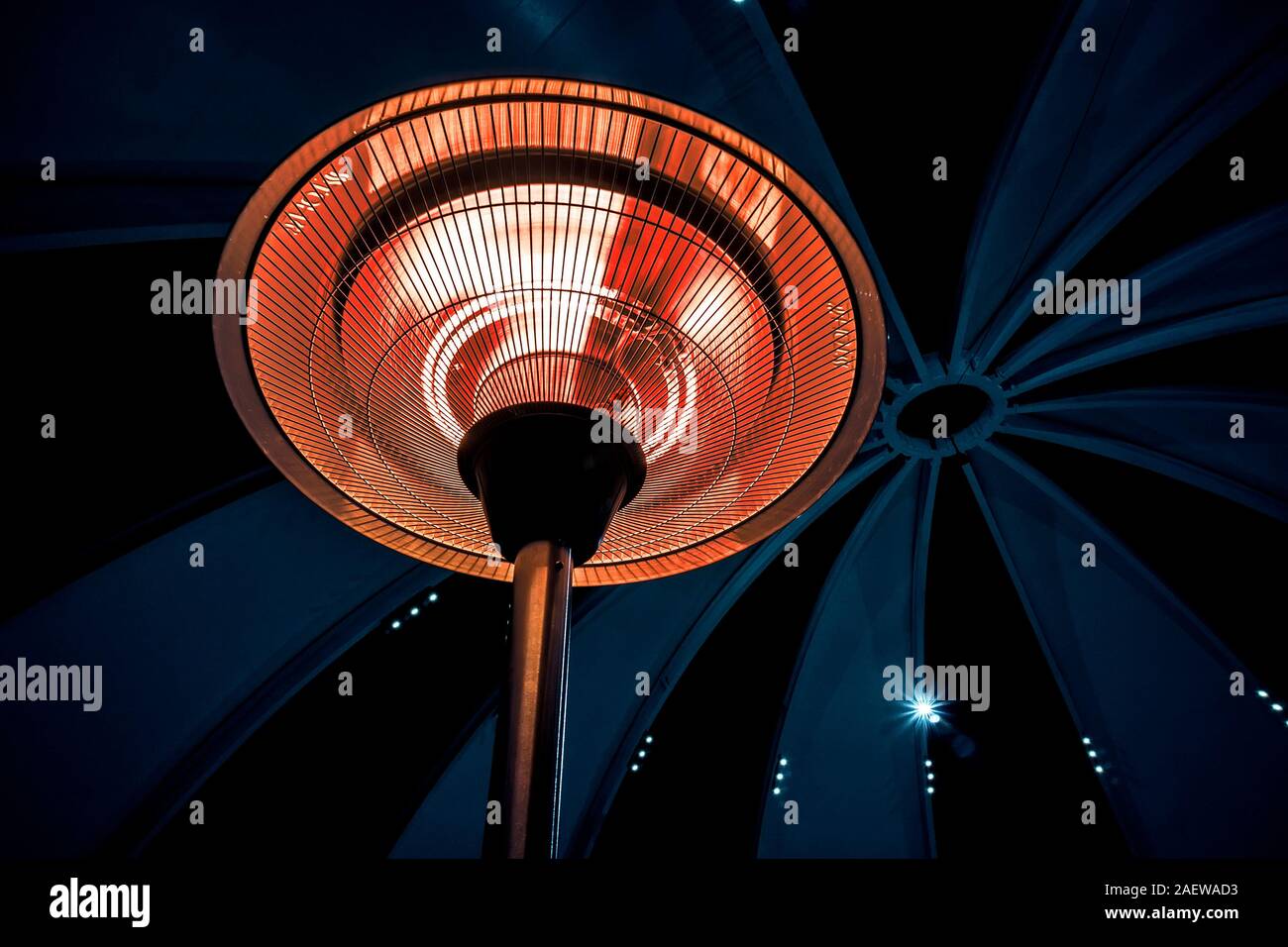 Infrared heater round shape on a black background in a large cold room ...