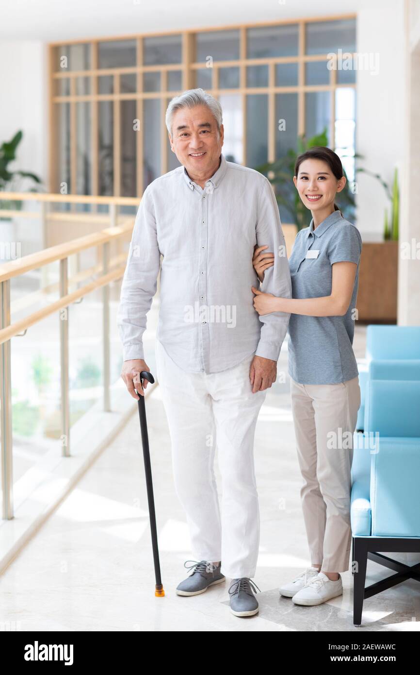 Nursing assistant taking care of senior man Stock Photo - Alamy