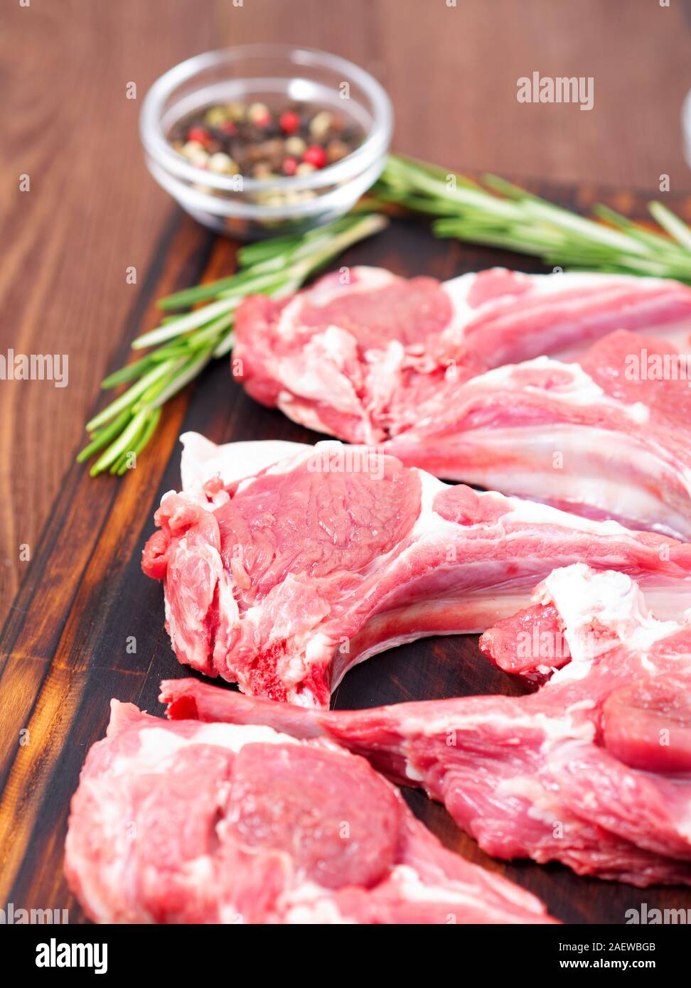 Raw lamb cutlets on bone on a dark brown wooden background, lamb ribs ...