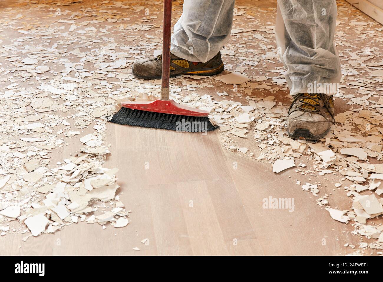 Builder sweeping the floor after renovation Stock Photo - Alamy
