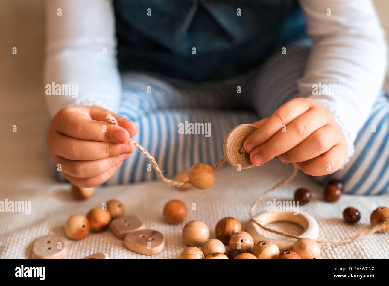 Child threading beads hi-res stock photography and images - Alamy