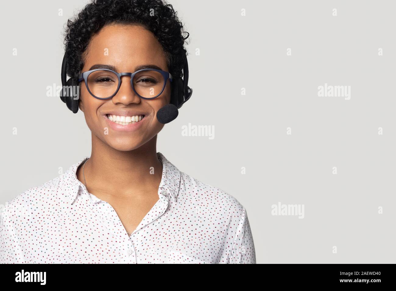 Young ethnic woman operator wearing wireless headset with mic portrait ...