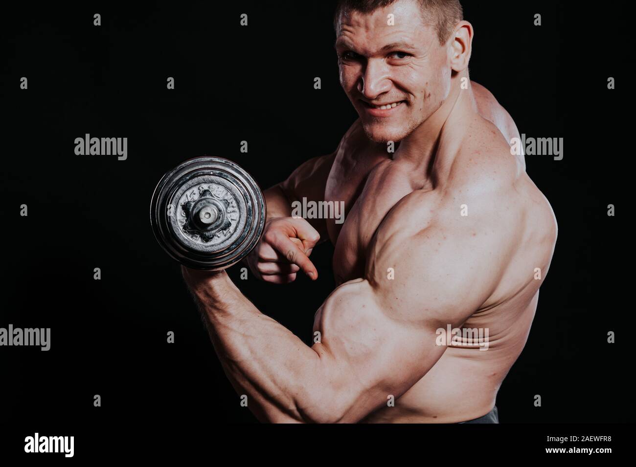 Sport the athlete bodybuilder build muscles dumbbells Stock Photo - Alamy