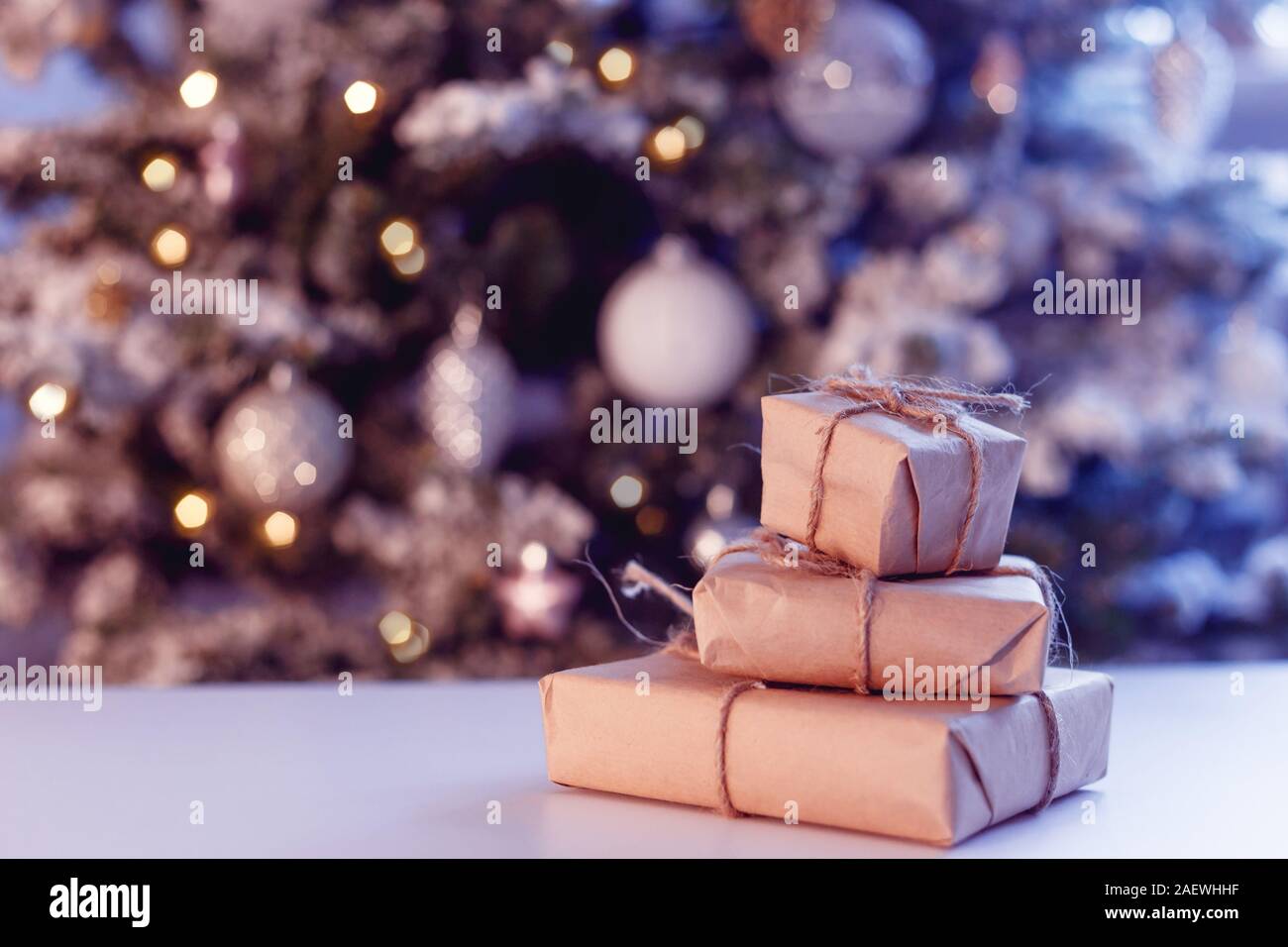 Stacks of Christmas presents with decorated Christmas tree in ...