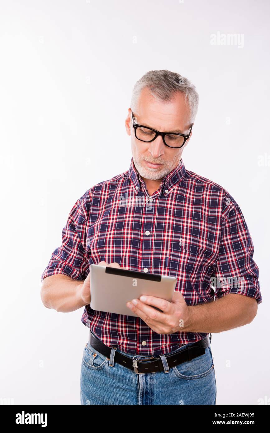 Confident gray aged man with glasses working with tablet Stock Photo ...