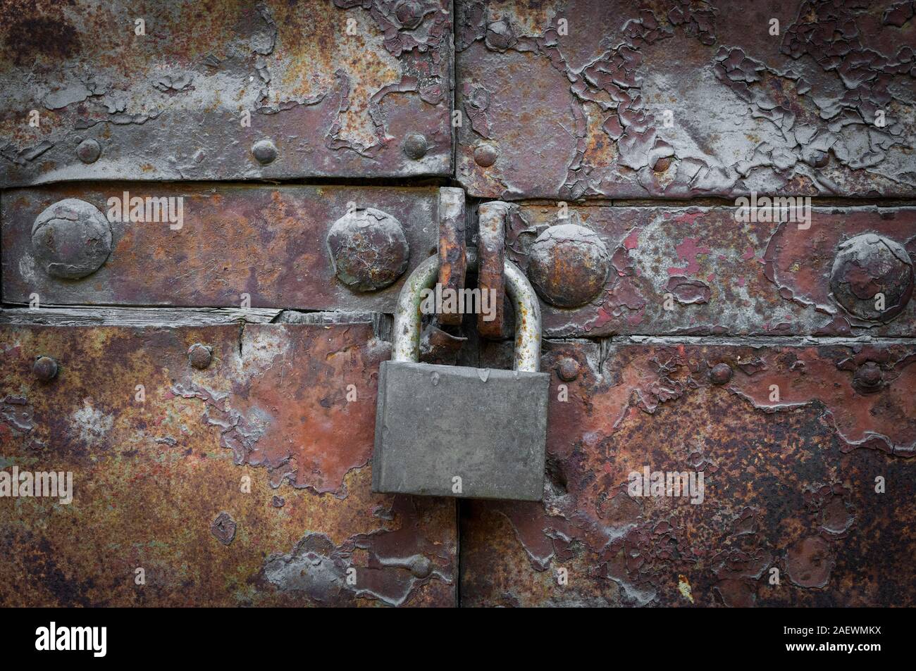 Privacy concept background: old rusty metal door closed with a massive ...