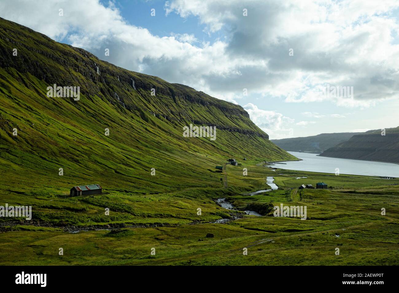 Landscape of Faroe Islands showing a farm surrounded by green mountains ...
