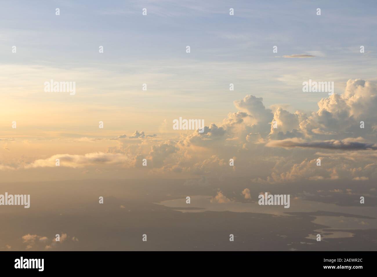 Dramatic cloudscape and landscape during sunrise from the airplane's ...