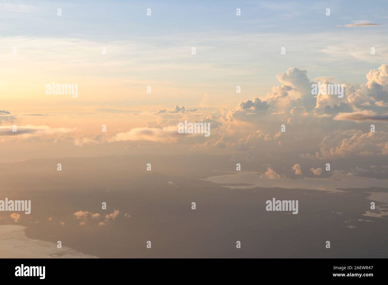Dramatic cloudscape and landscape during sunrise from the airplane's ...